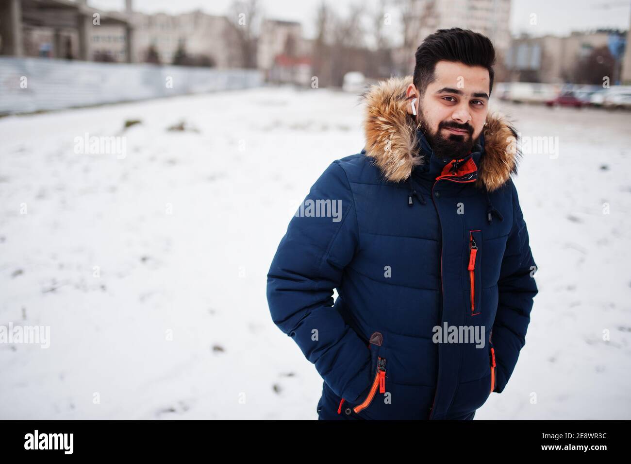 Beard indian man wear jacket in cold winter day. Mobile earphones in ...