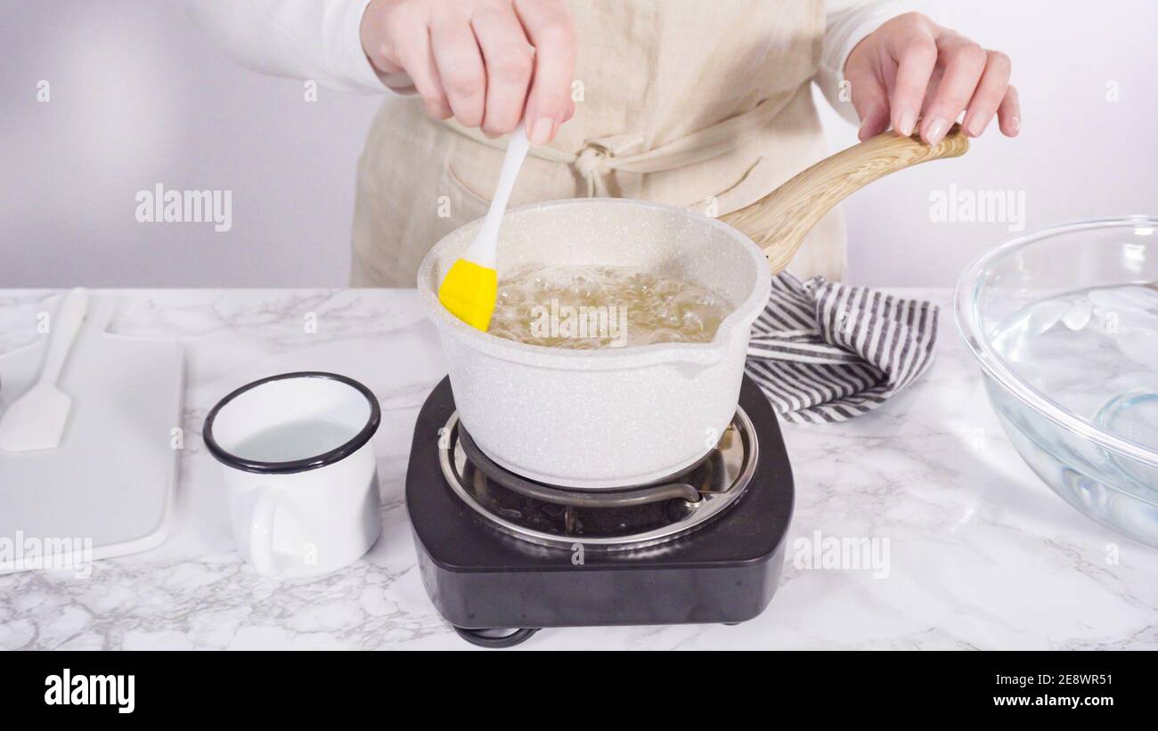 Step by step. Caramelizing sugar in a small cooking pot over the small ...