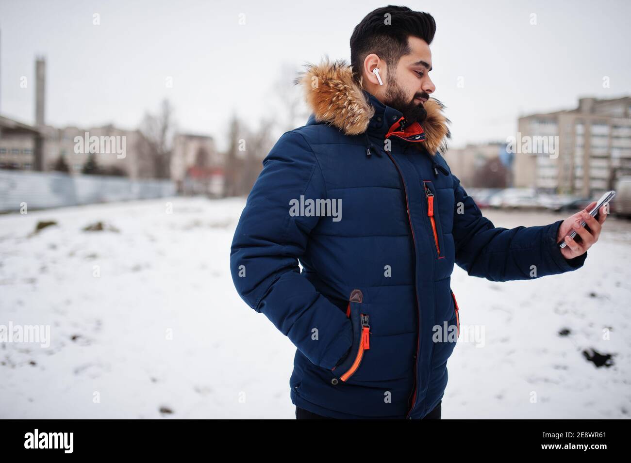 Beard indian man wear jacket in cold winter day. He speak mobile phone ...