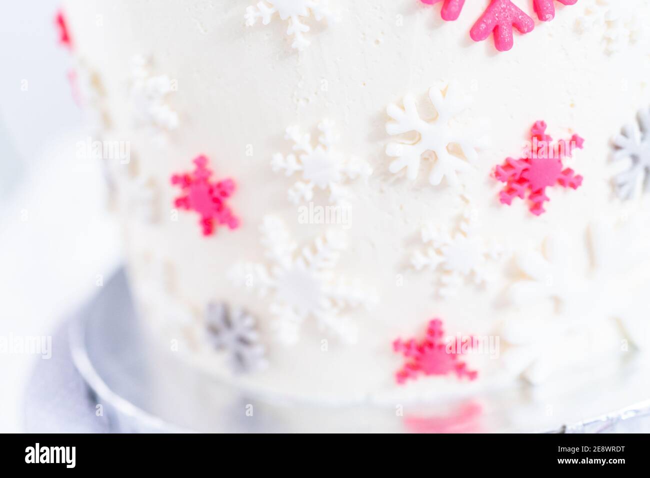 Frosting a tall round cake with white Italian buttercream icing and ...