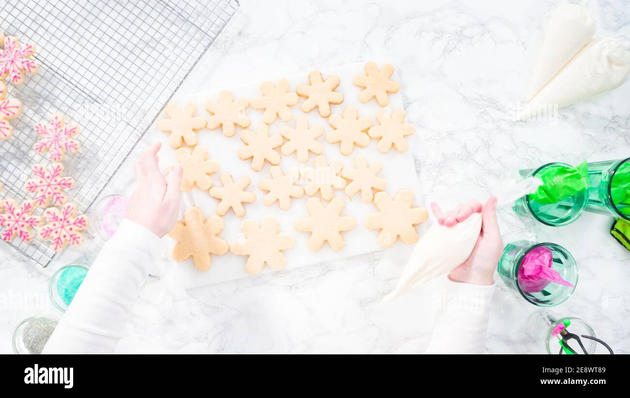 Flat lay. Stp by step. Icing snowflake shaped sugar cookies with white ...