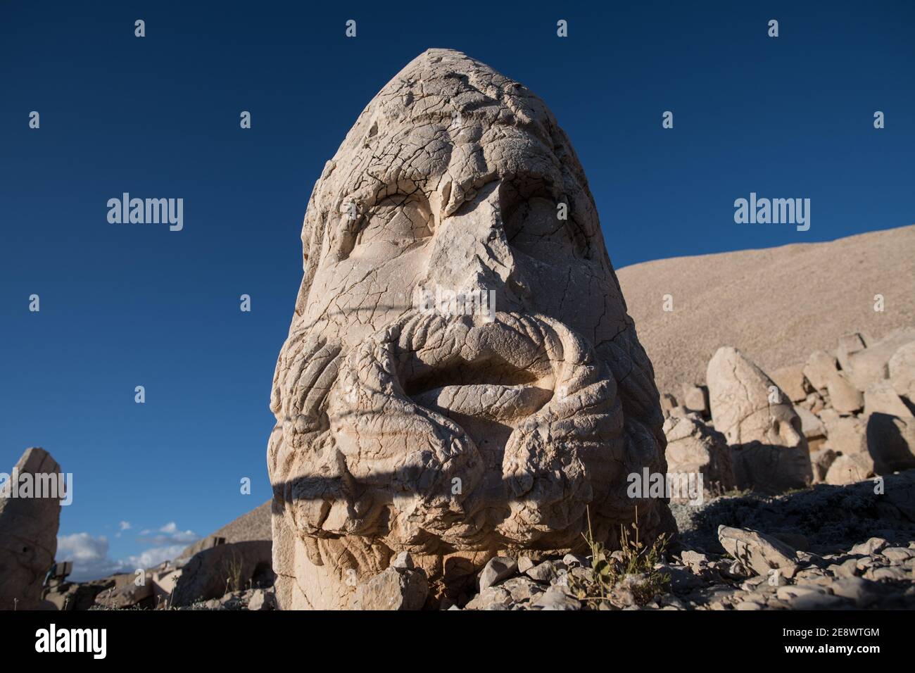 A close-up of an ancient stone head at Mount Nemrut, Turkey, revealing ...