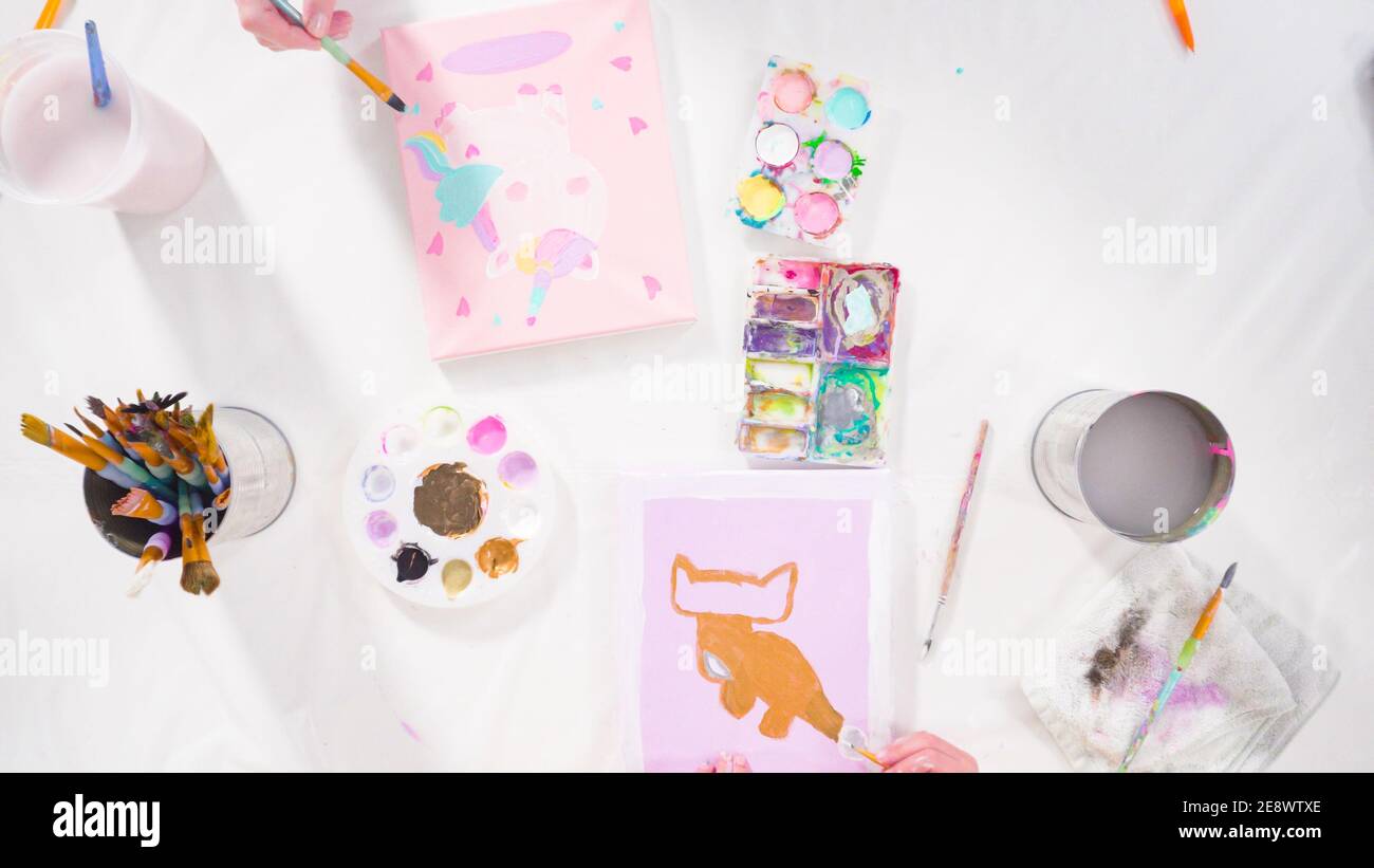Flat lay. Little girl painting with acrylic paint on canvas with her ...