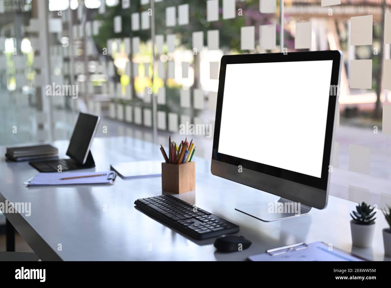 Side view of computer with blank screen and tablet on modern ...