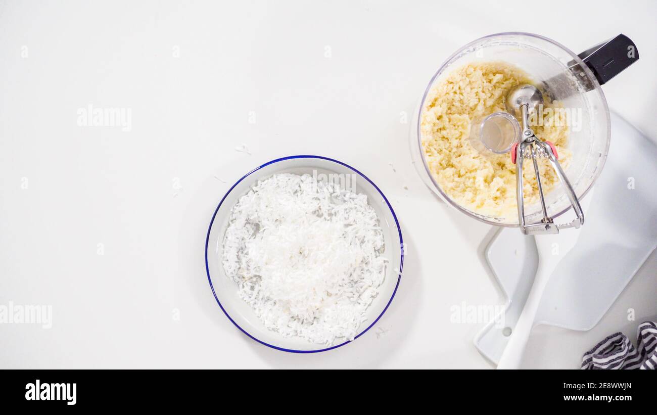 Flat lay. Scooping cookie dough into the baking sheet to bake coconut ...