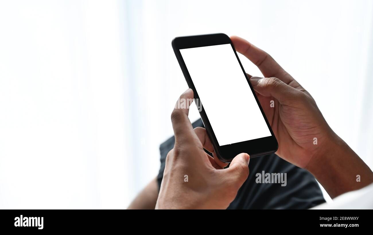Close up view of man hands holding smart phone with white screen. Blank ...