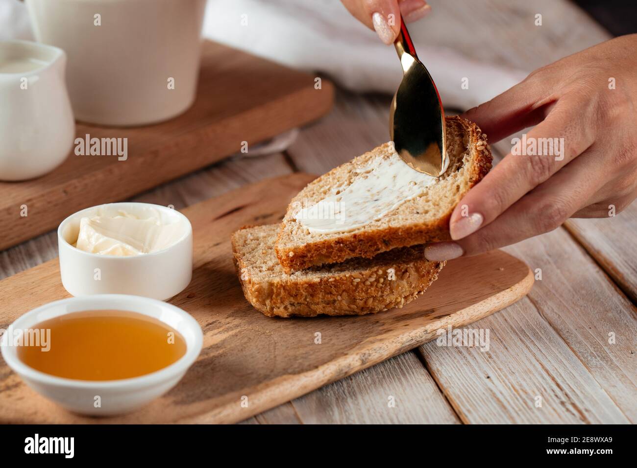 Side view on spreading bread slice with butter Stock Photo - Alamy