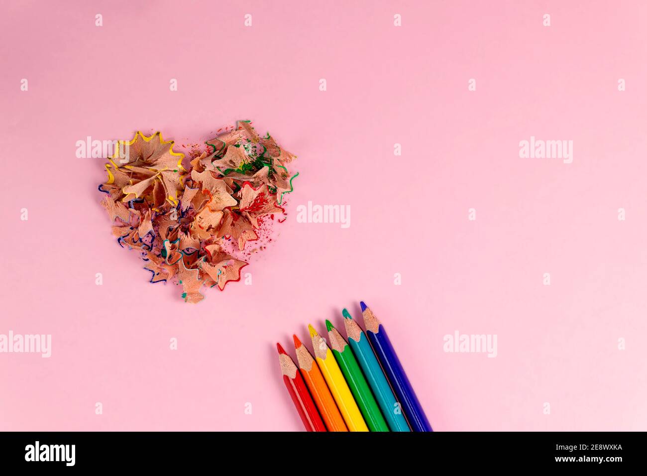 Sharpened colored pencils and heart-shaped pencil shavings on pastel ...