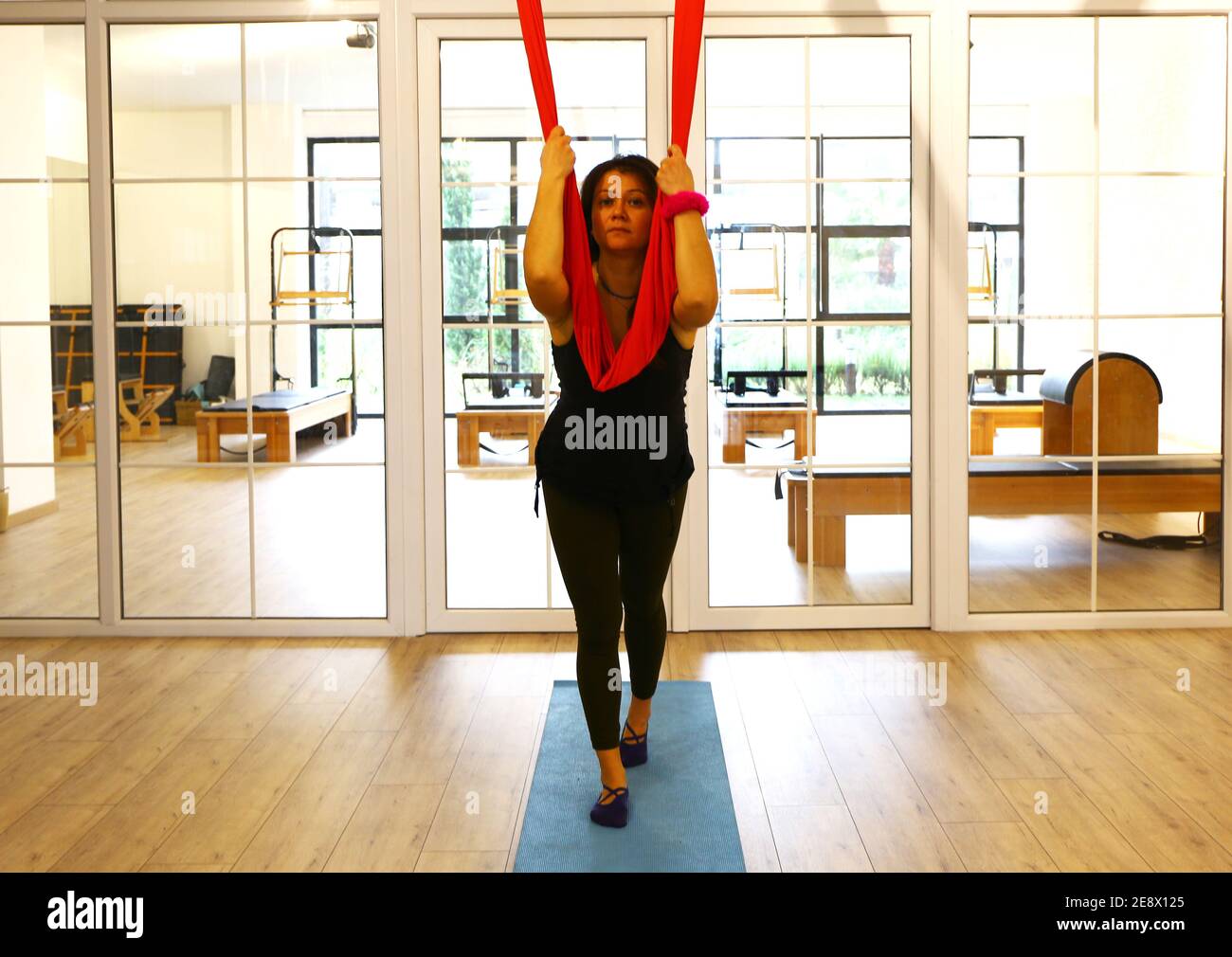 Yoga instructor showing hammock yoga poses. This style of yoga also ...