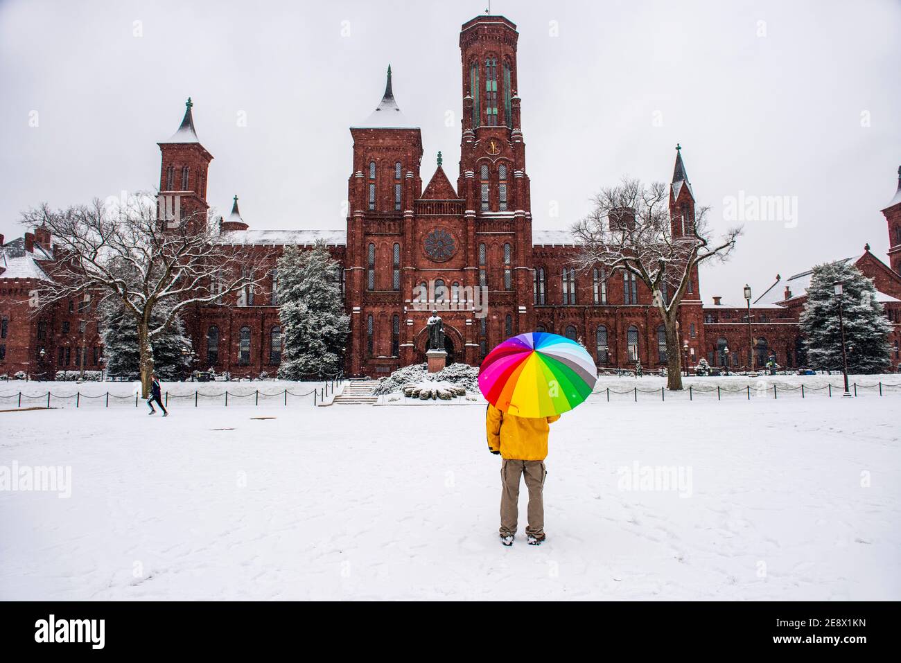 A man with a colorful umbrella stops in front of the Smithsonian ...