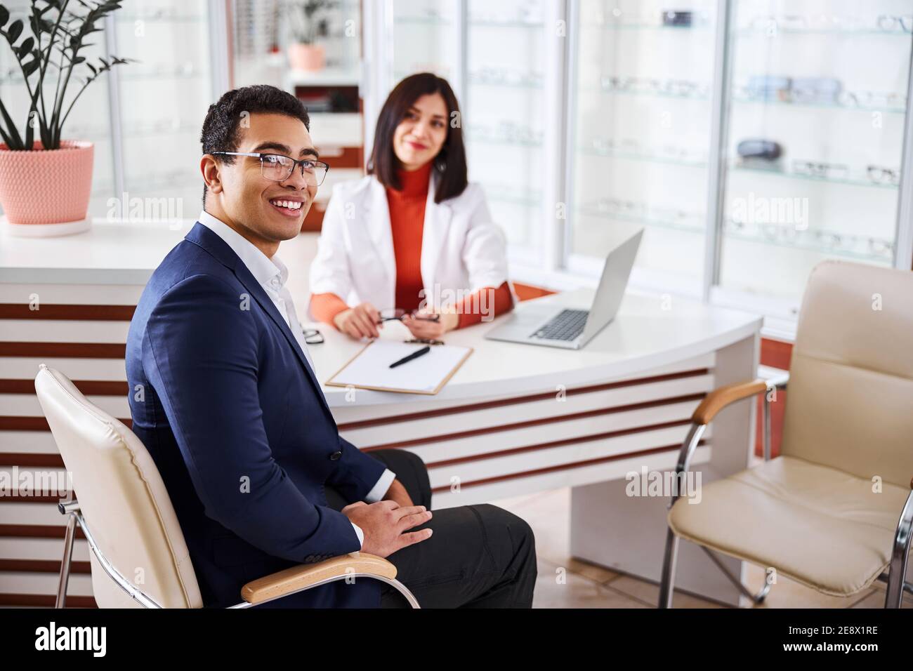 Pleased client smiling at the camera at the optician office Stock Photo ...