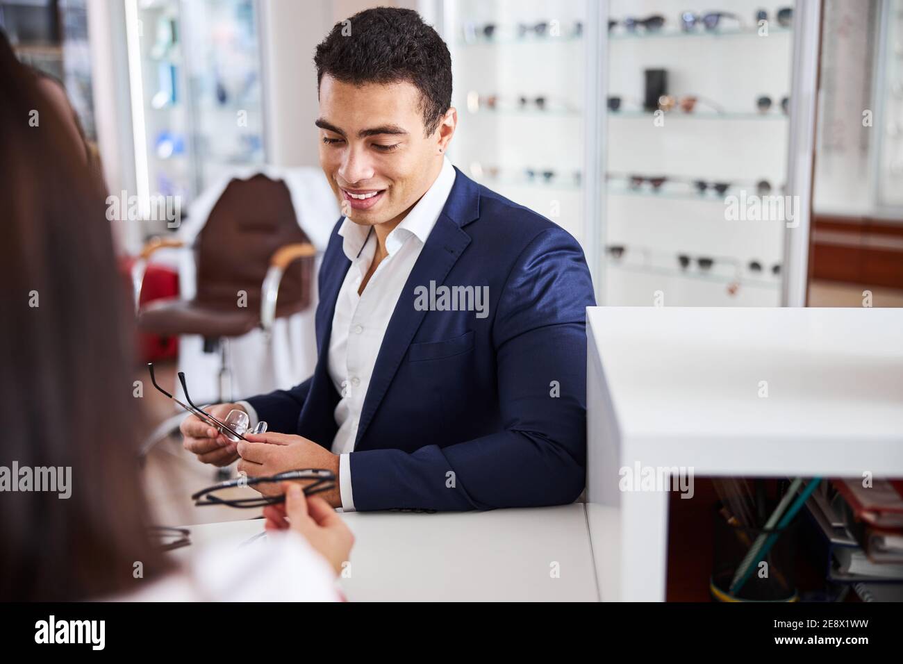 Optician advising a customer on choosing the appropriate eyewear Stock ...