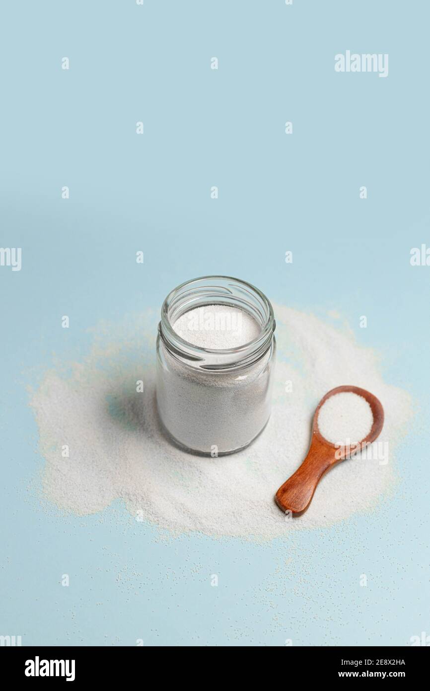 Collagen powder or protein in a glass jar and small wooden spoon on ...