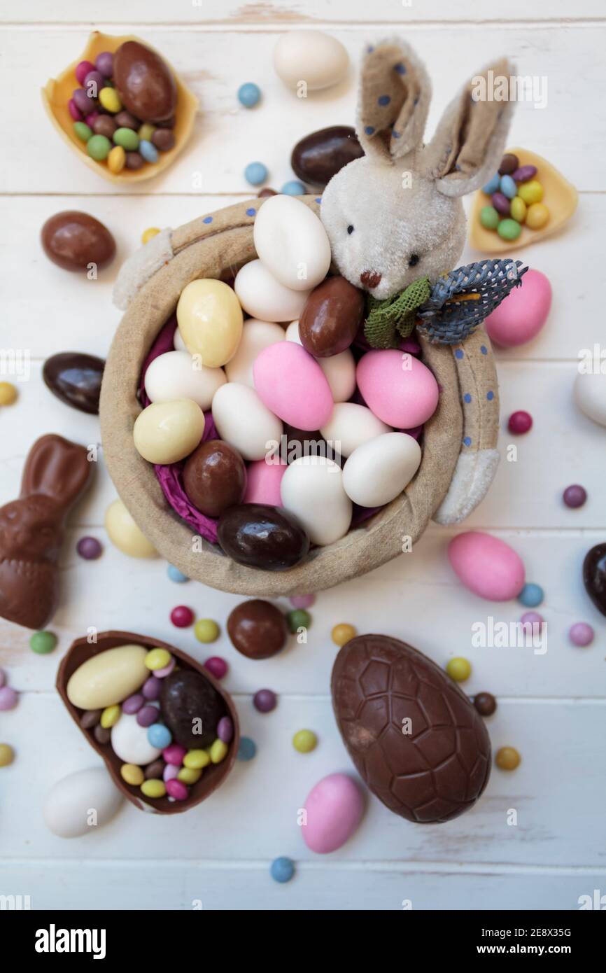 Top view of easter bunny basket with almonds, chocolate eggs and other ...