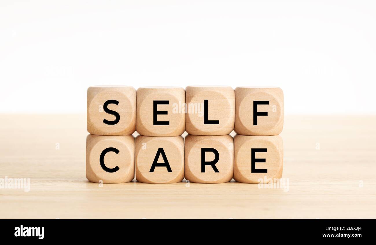 Self care word on wooden blocks on wood table. Copy space. White ...
