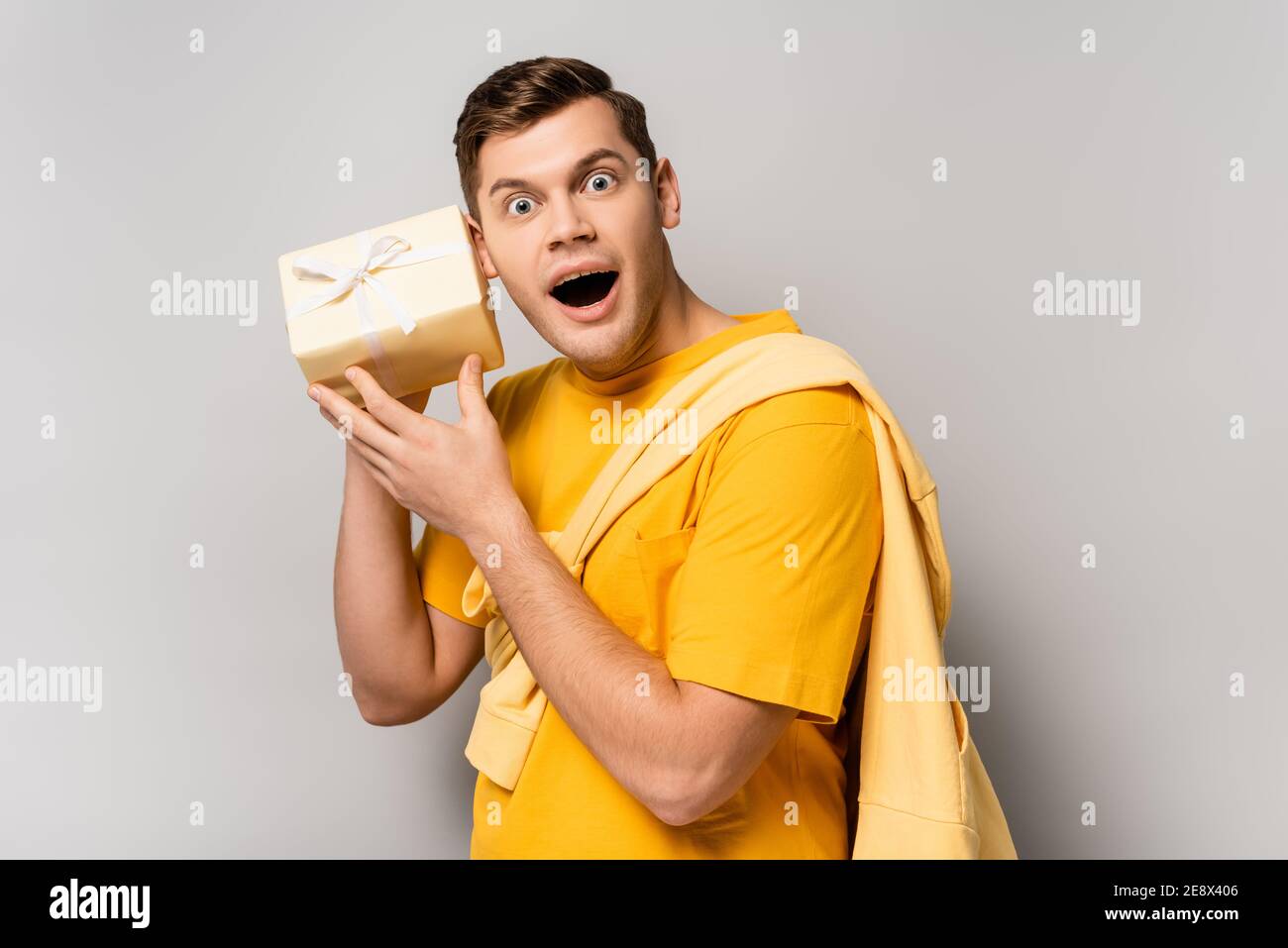 Excited man holding present hi-res stock photography and images - Alamy
