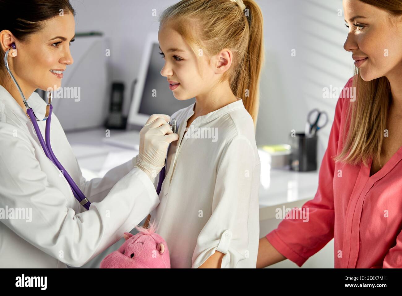 pediatrician using stethoscope for listening lungs and heart of child ...