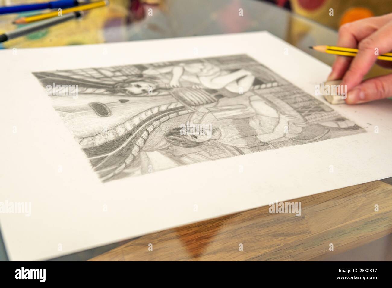 Close-up of hands making a figurative drawing in black and white ...