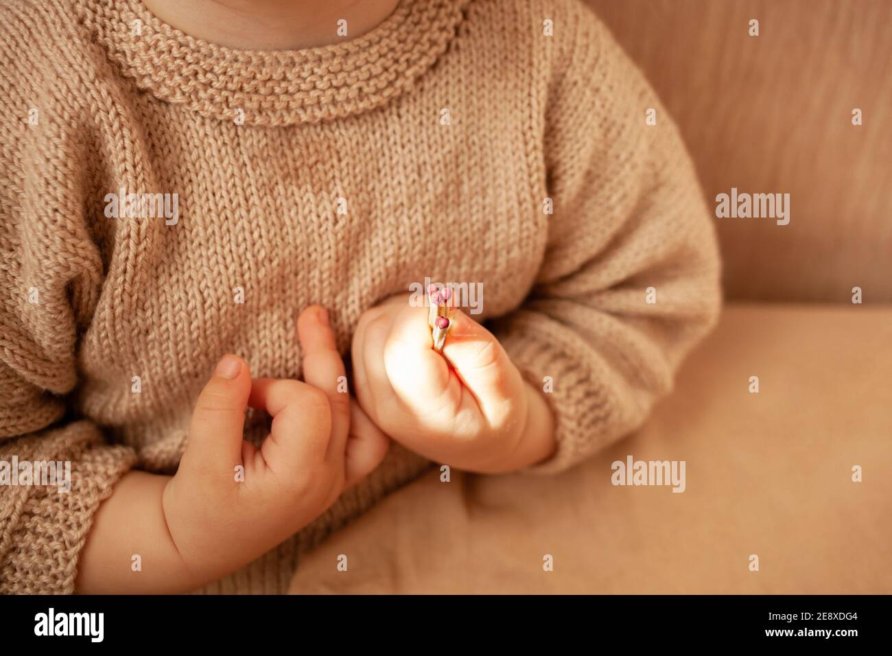 The child plays with Lucifer match, danger in the house. A small child ...