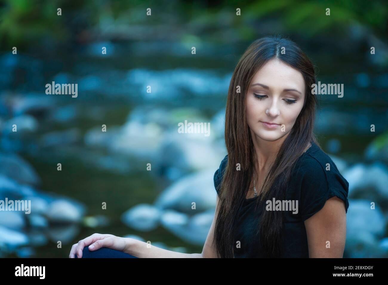 A young woman poses along the banks of a small river Stock Photo - Alamy