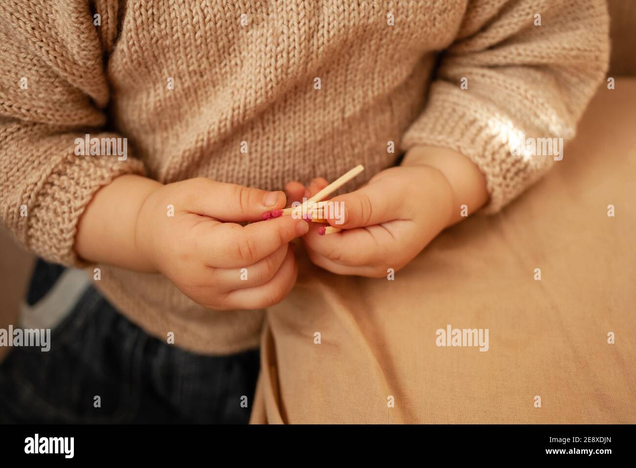 The child plays with Lucifer match, danger in the house. A small child ...