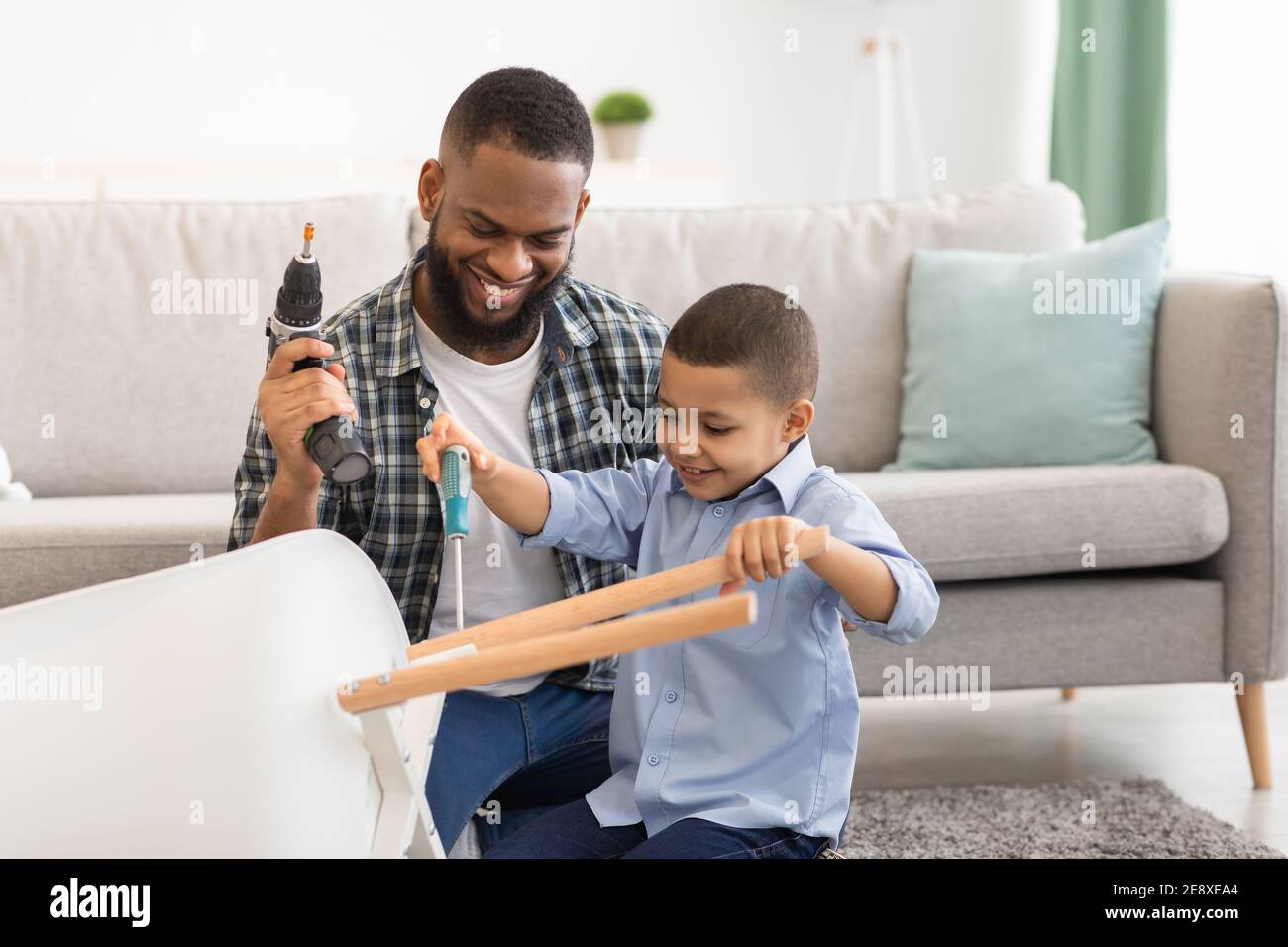 African Boy Helping Father Fix Table Doing Housework At Home Stock ...