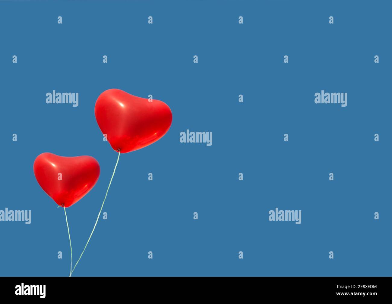 Two red balloon in the blue sky. Symbol of strong love and tenderness ...