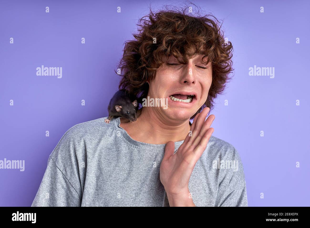 funny man at a loss, does not know what to do with a rat on his t-shirt ...