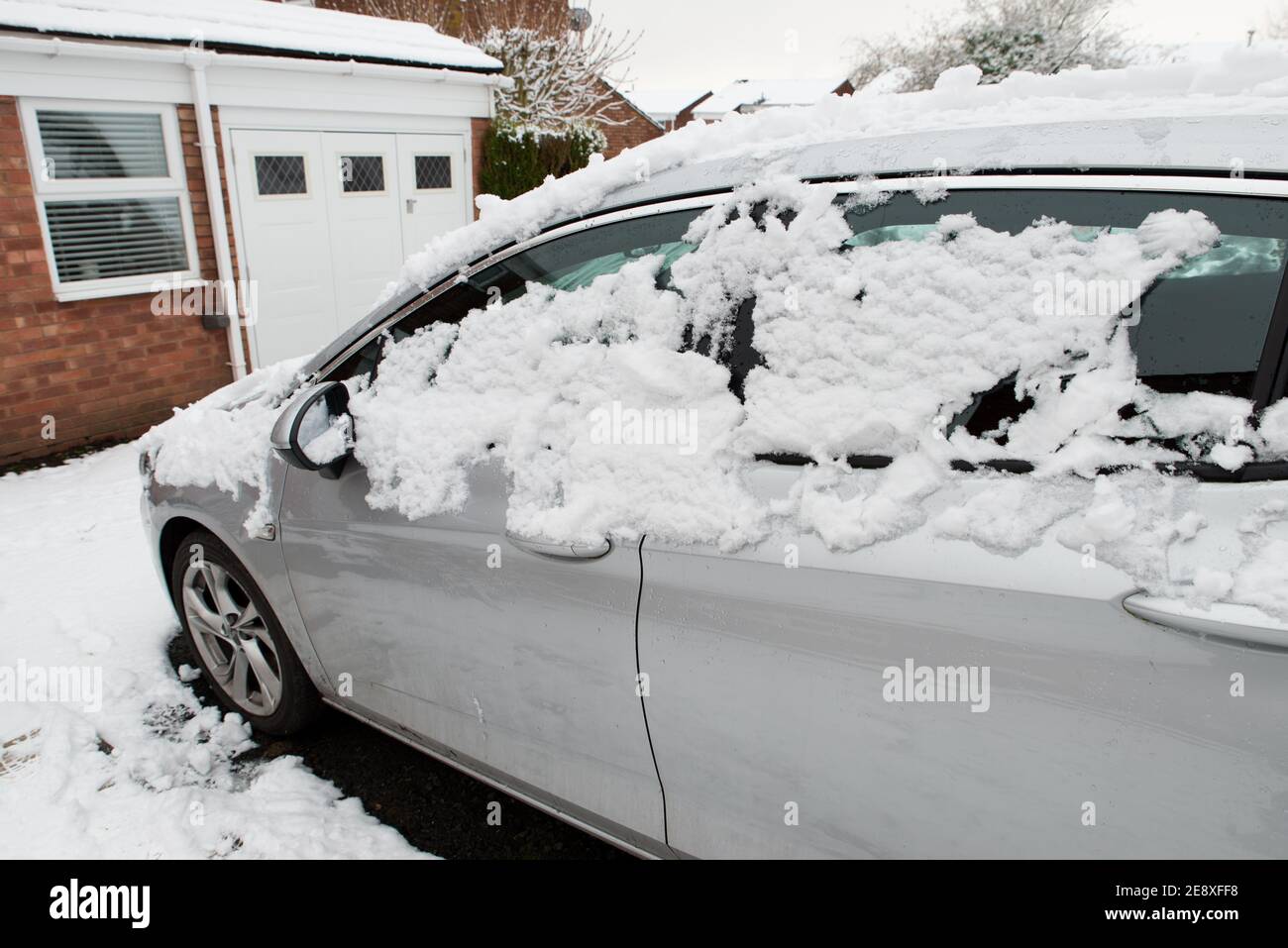 close up of silver grey car covered in snow parked driveway in front of ...
