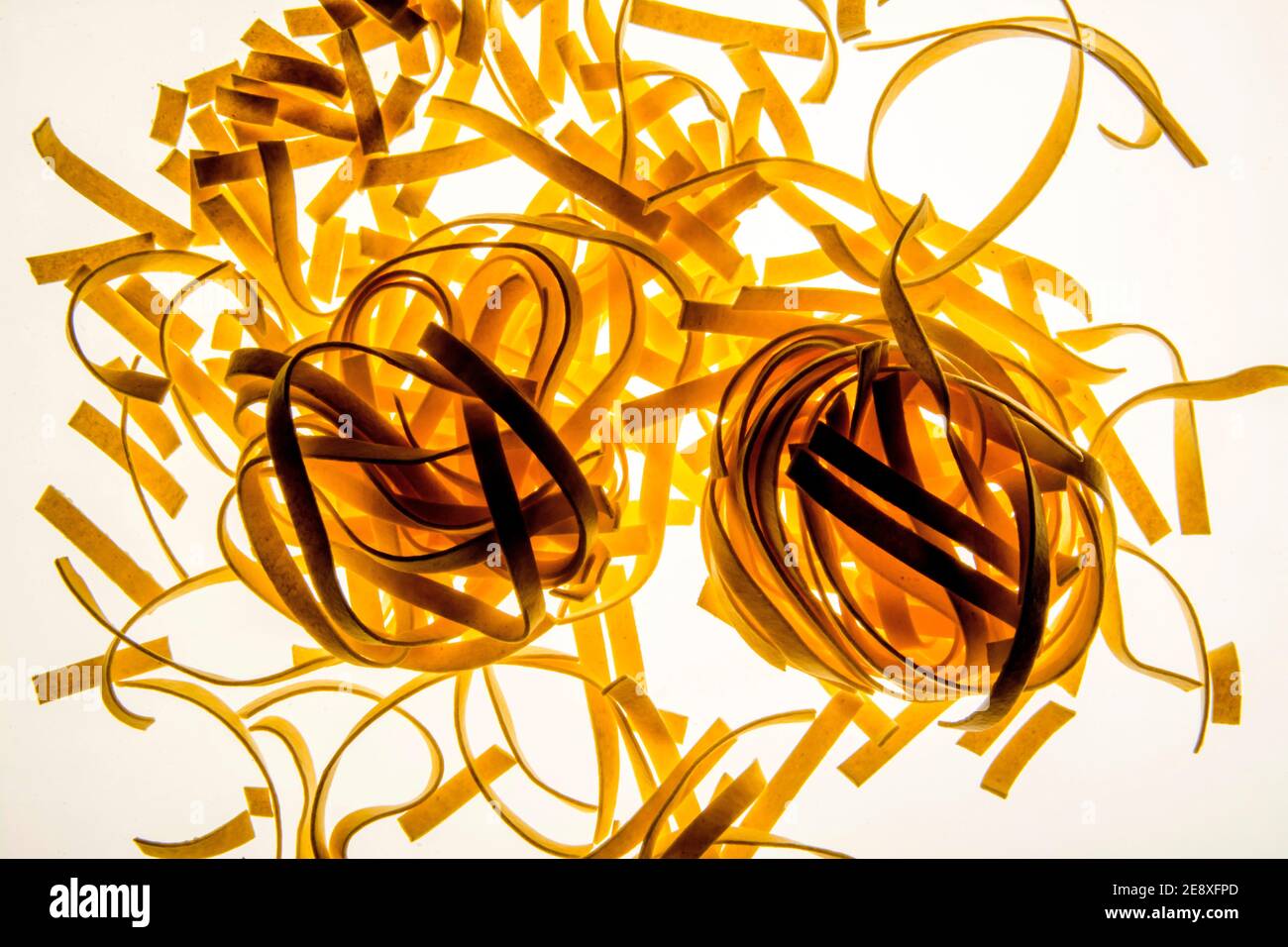 Fresh pasta strands elegantly arranged against a bright background ...