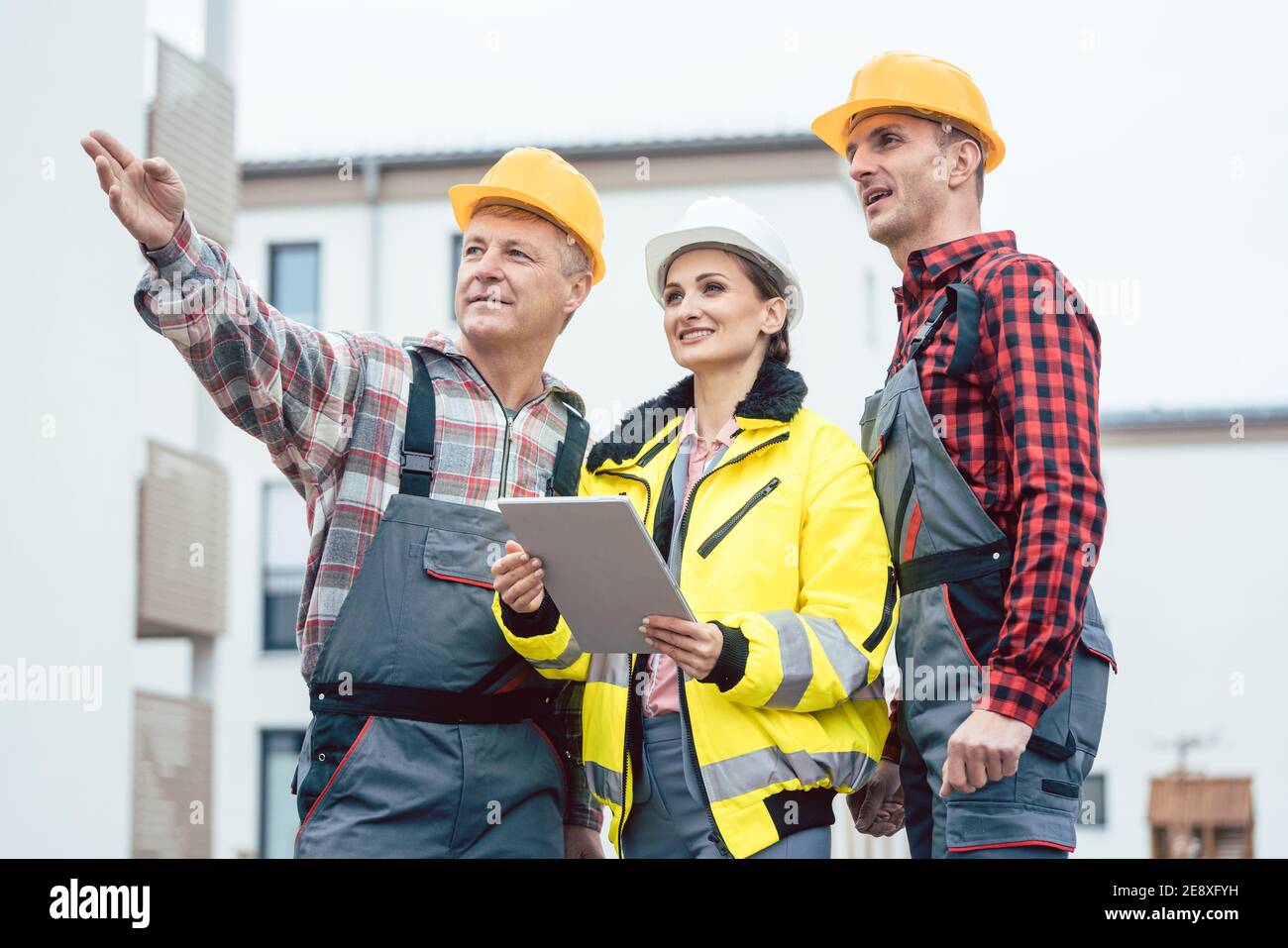 Builder and contractor inspecting new houses on construction site Stock ...