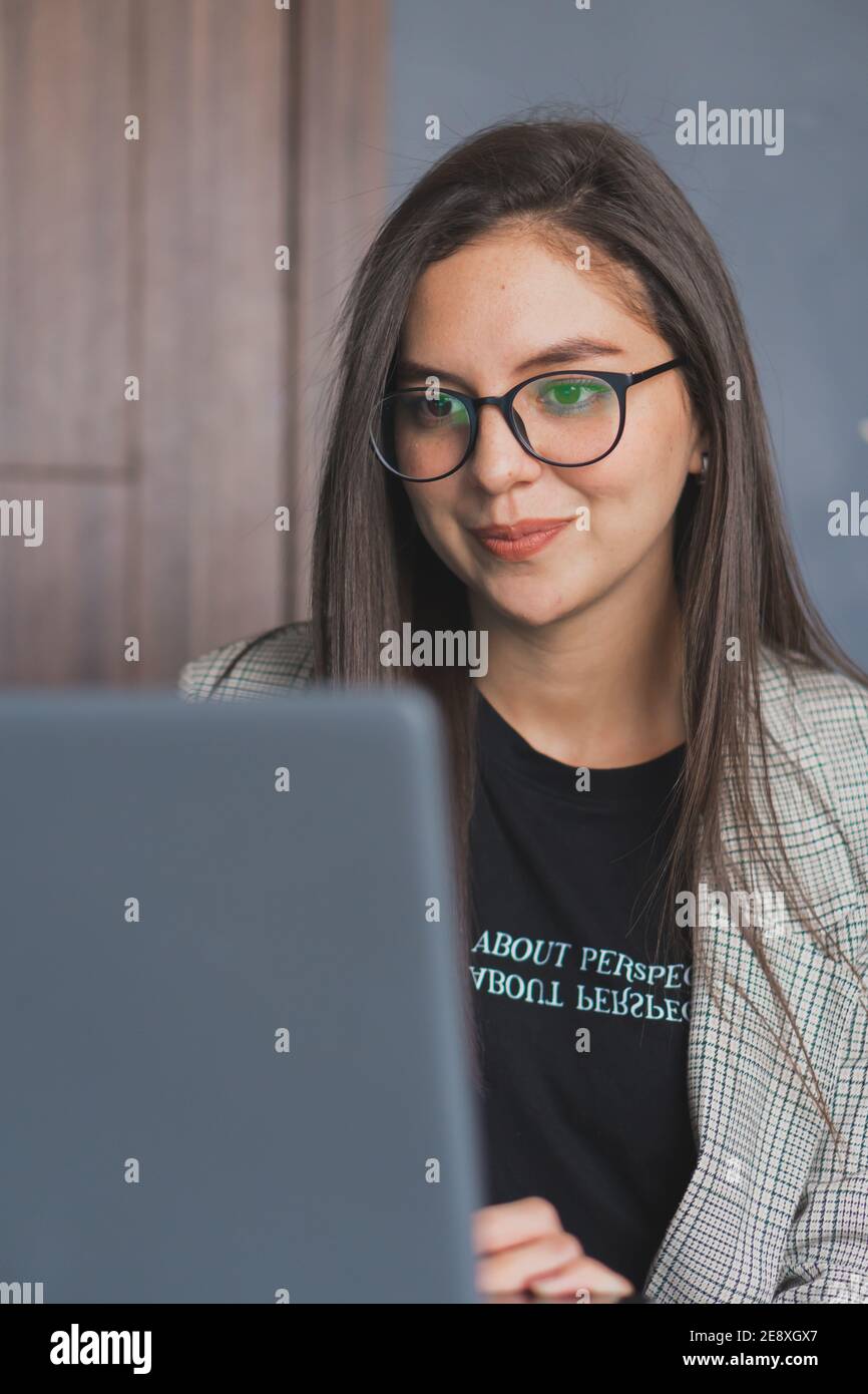 Young woman with her laptop. Performing various tasks and meetings ...