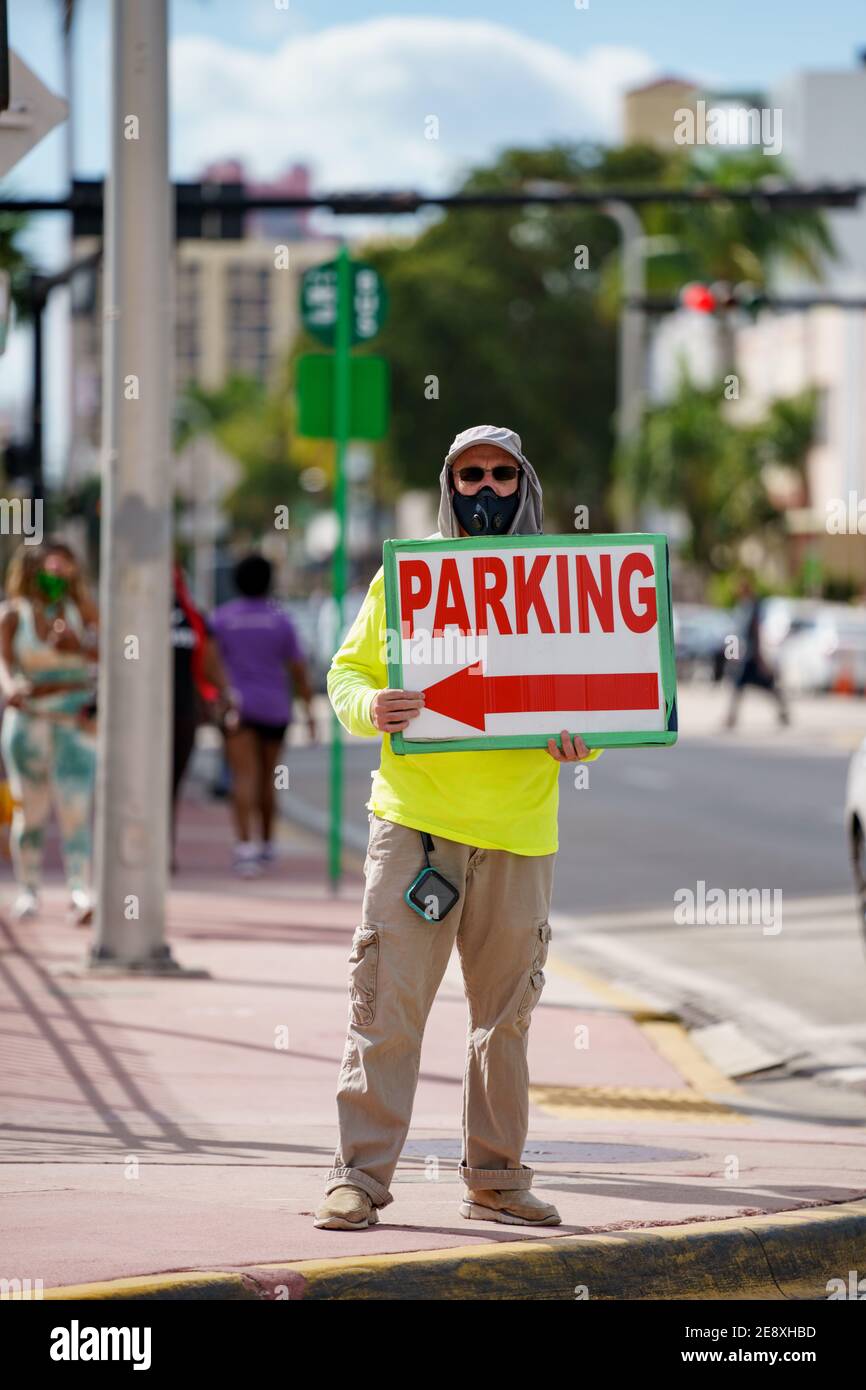Man holding a parking sign in Miami Beach street photography Stock ...
