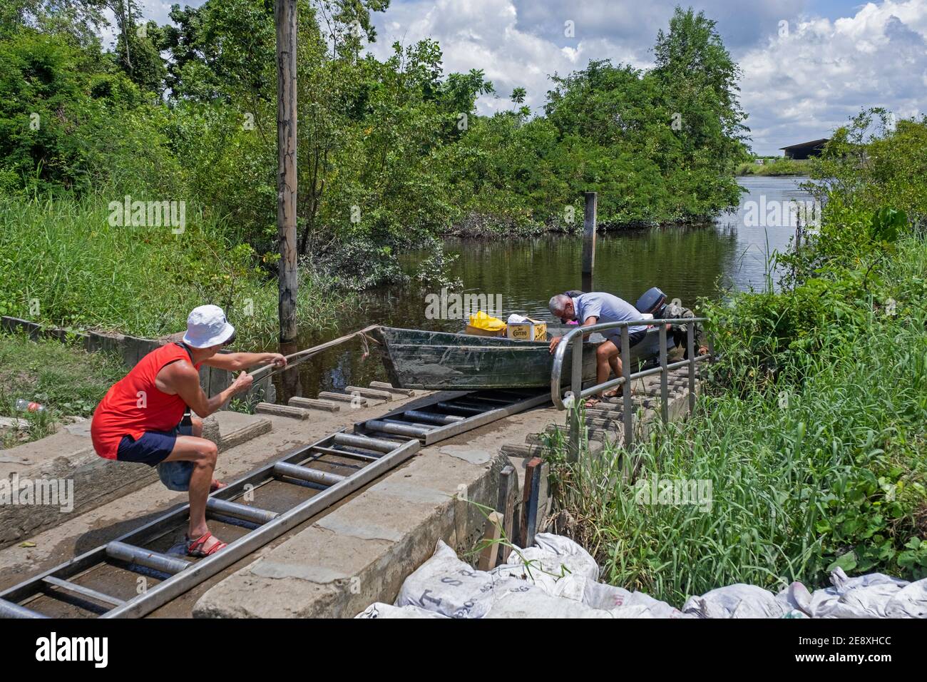 Tourists pulling boat over ramp from water that leads to the Bigi Pan ...