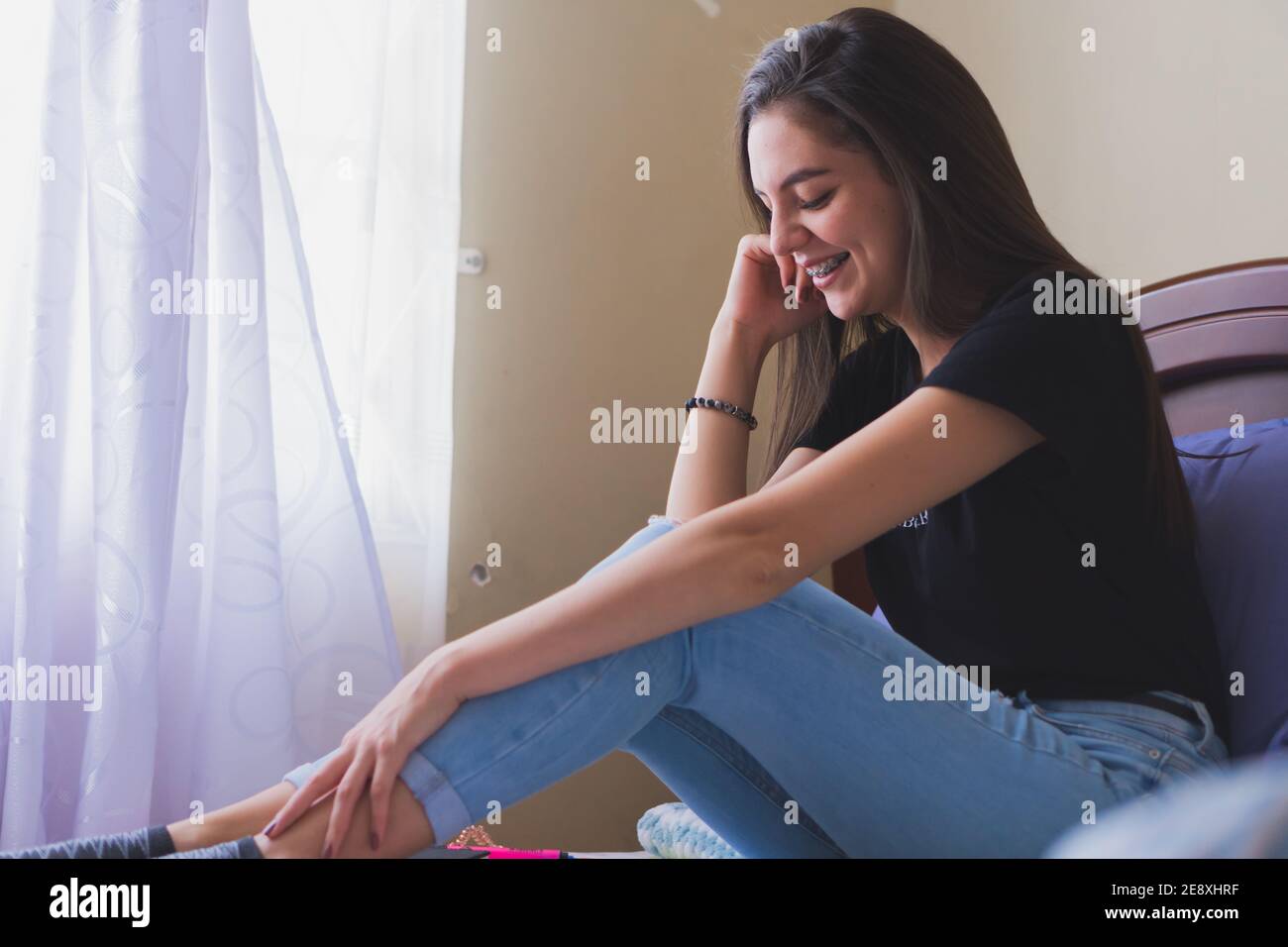 Young woman having a nice time. In his room remembering happy moments ...