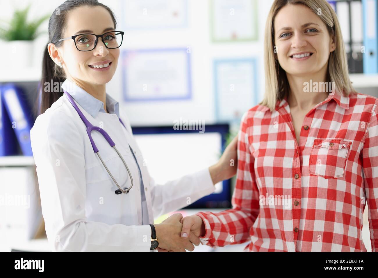 Doctor smiling and shaking patients hand in clinic Stock Photo - Alamy