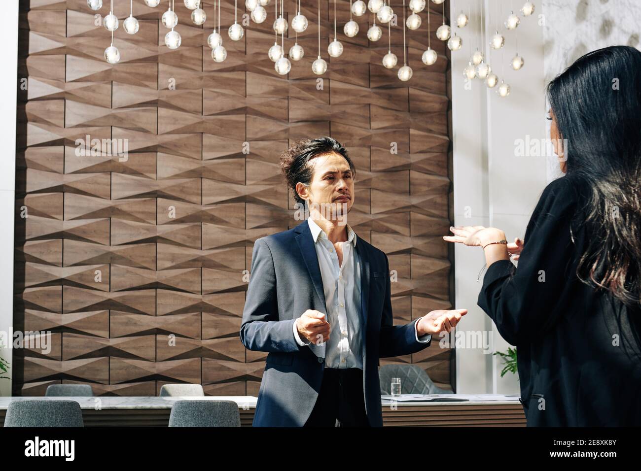 Emotional colleagues talking Stock Photo - Alamy