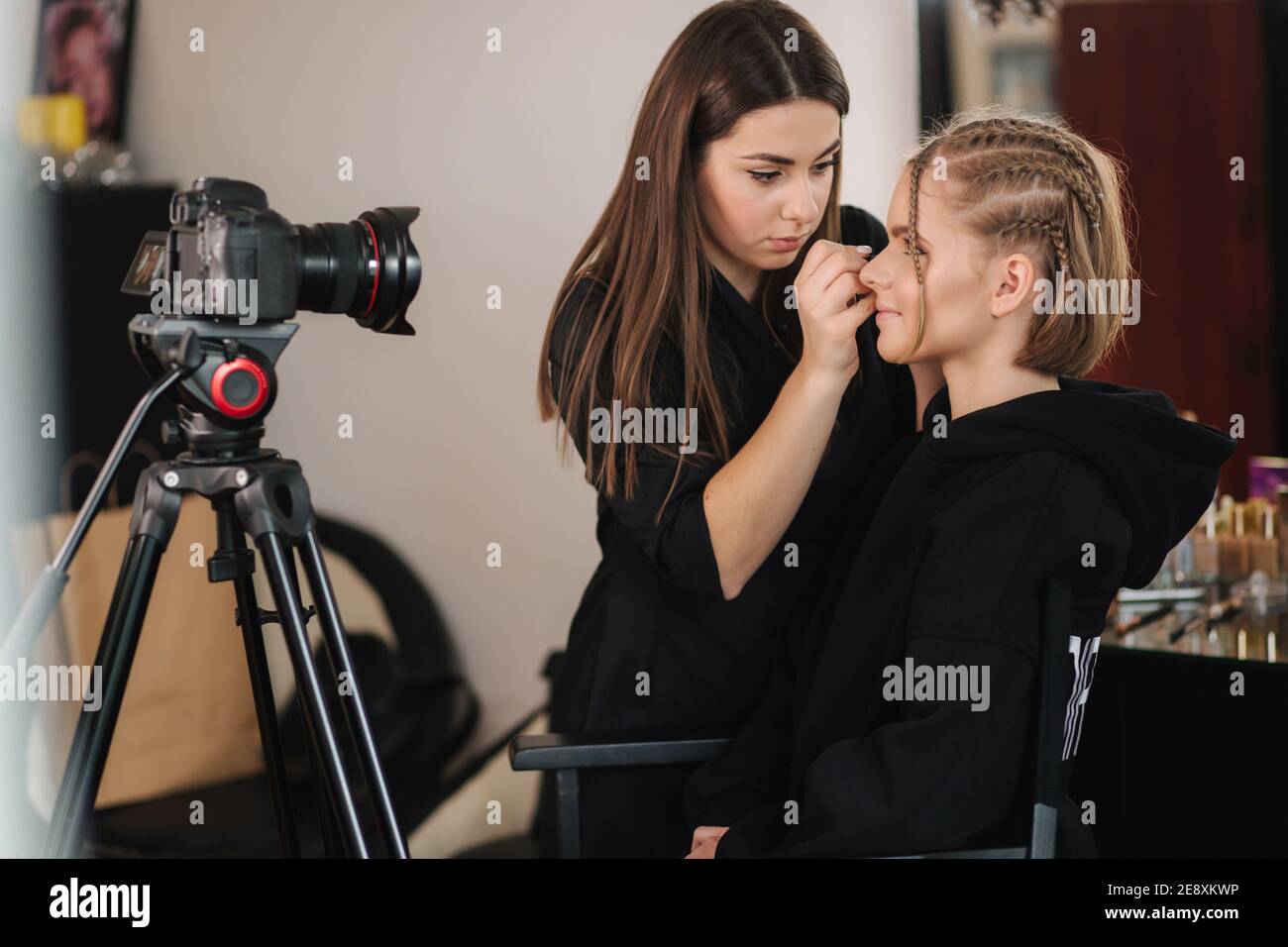 Side view of make up artist work with beautiful blond hair model in ...