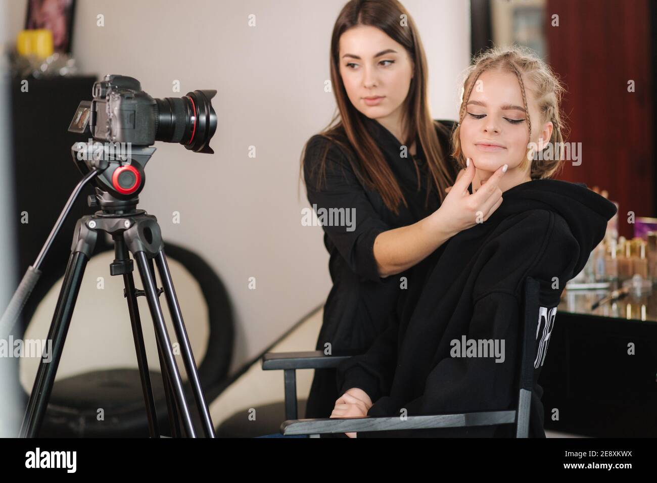 Side view of make up artist work with beautiful blond hair model in ...