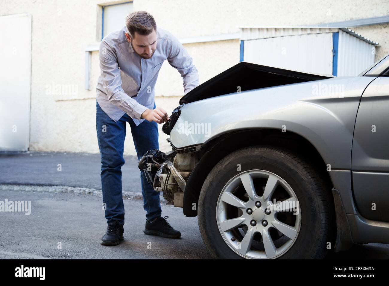Driver man looking on wrecked car in car accident. Man regrets about ...