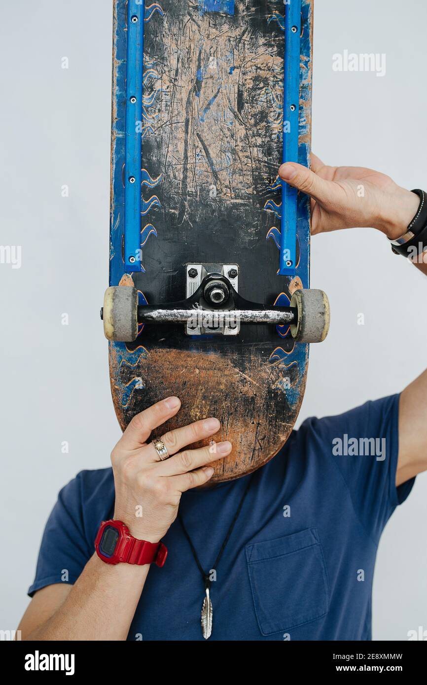 Silly man having fun, holding board with both hands, blocking head ...