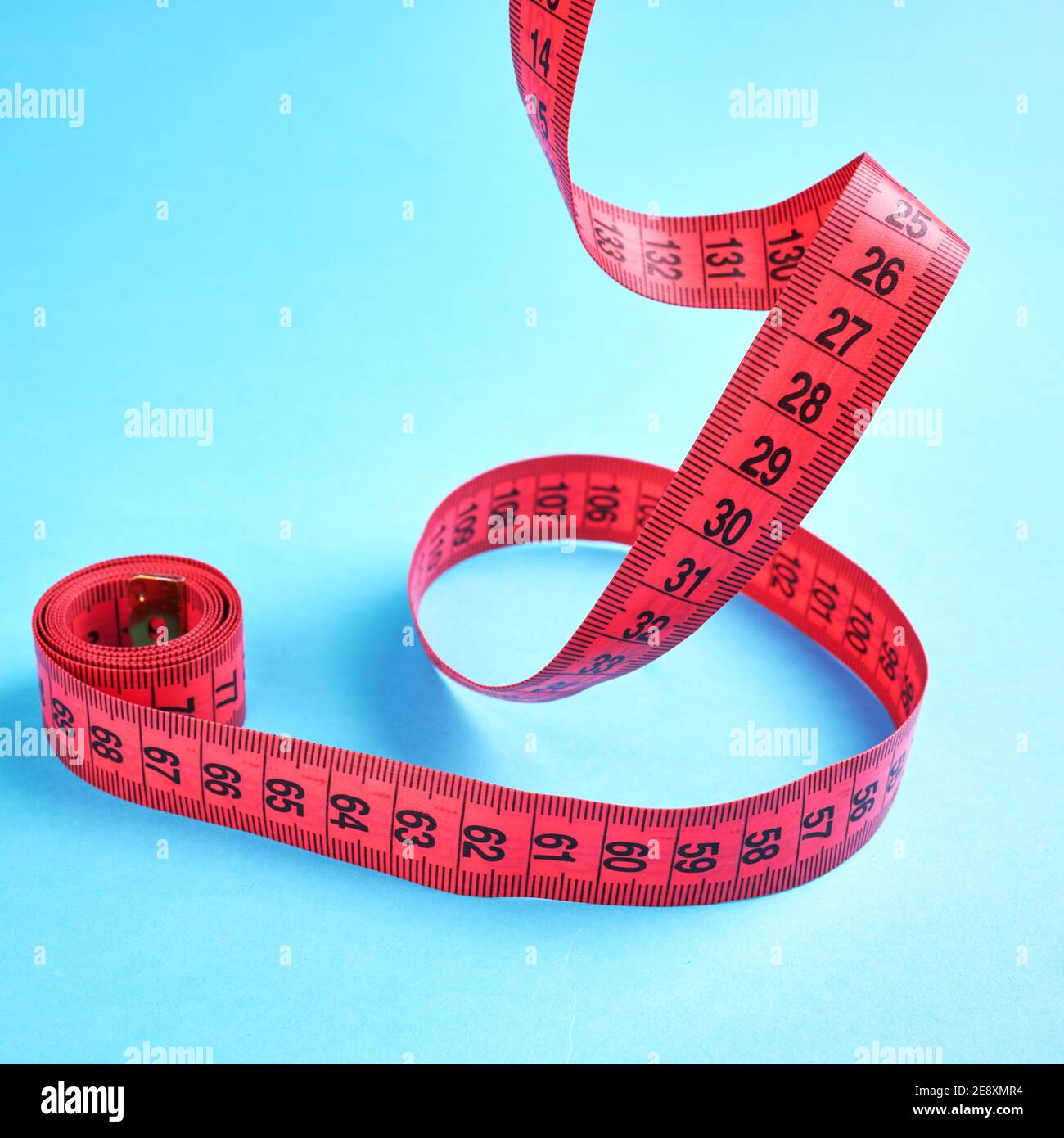 weight loss measuring concept. red centimeter balancing over blue ...