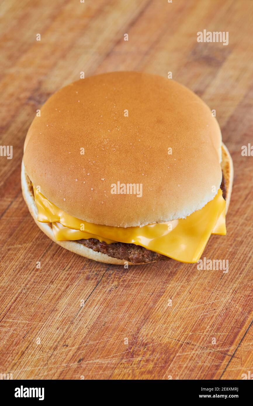 thin cheeseburger or hamburger on a wooden board with diagonal lines ...