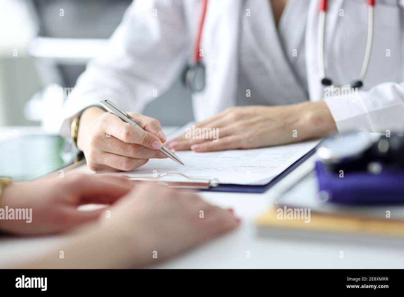 Doctor advising patient and writing in documents closeup Stock Photo ...