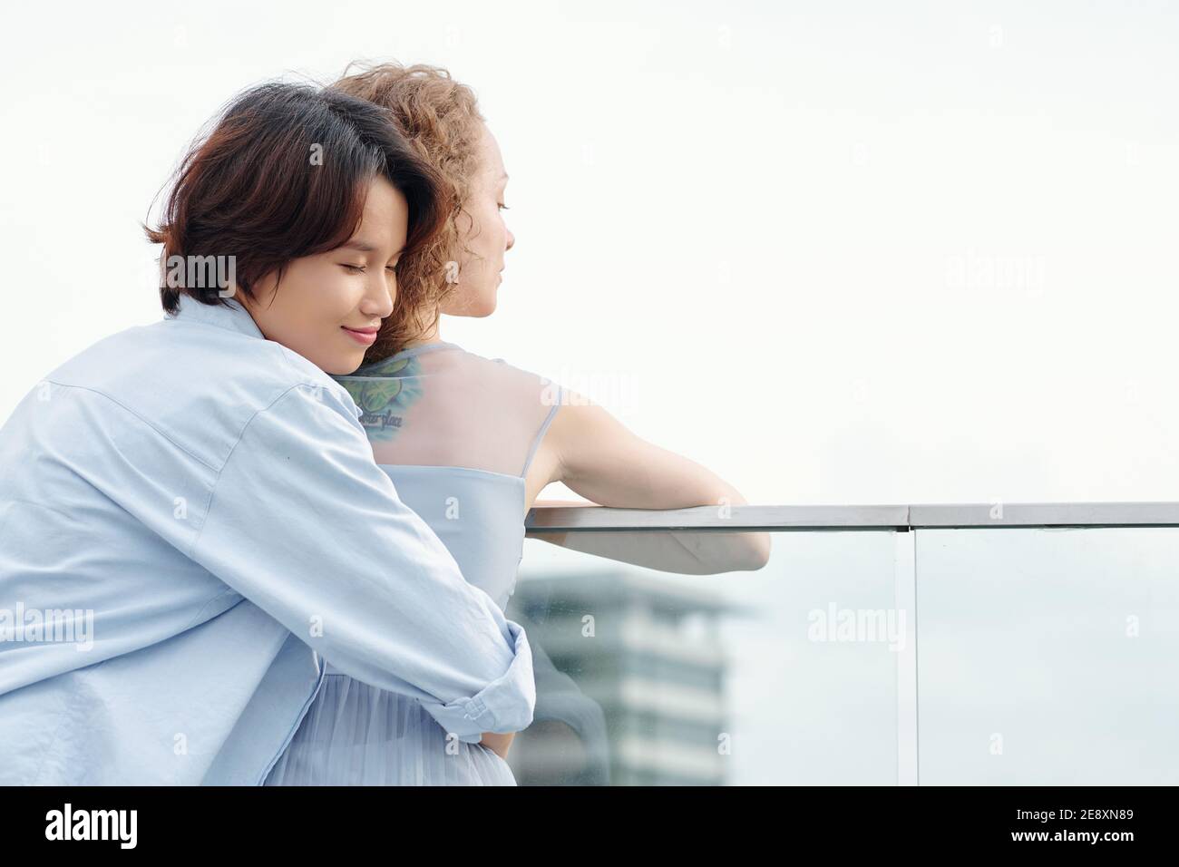 Pretty woman hugging girlfriend Stock Photo - Alamy