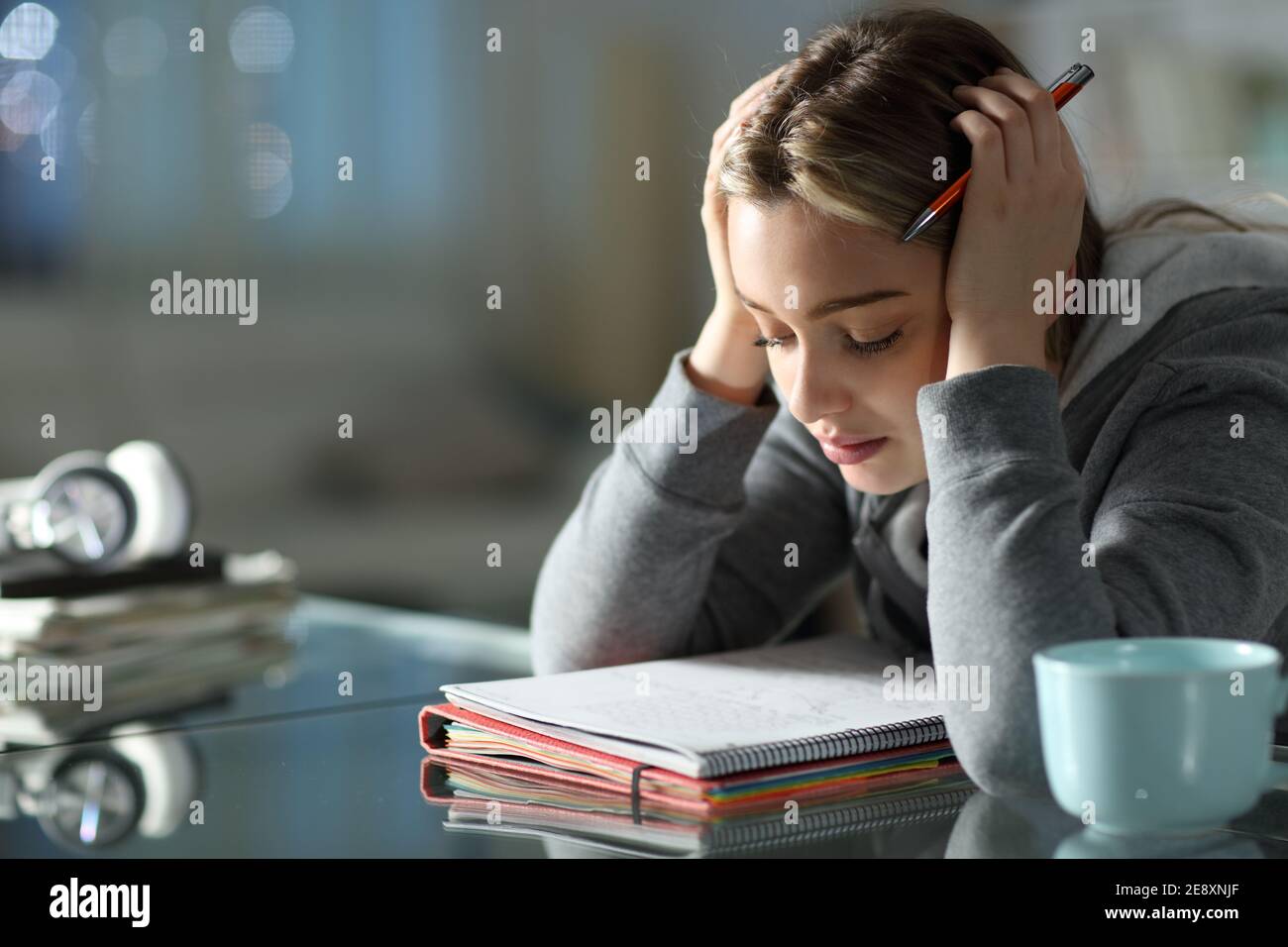 Concentrated student studying memorizing notes in the night at home ...