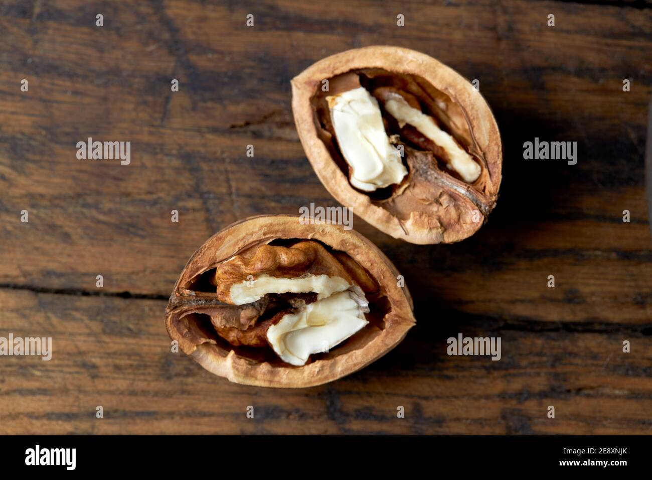 open halves of a fresh raw walnuts on a grunge wooden background ...