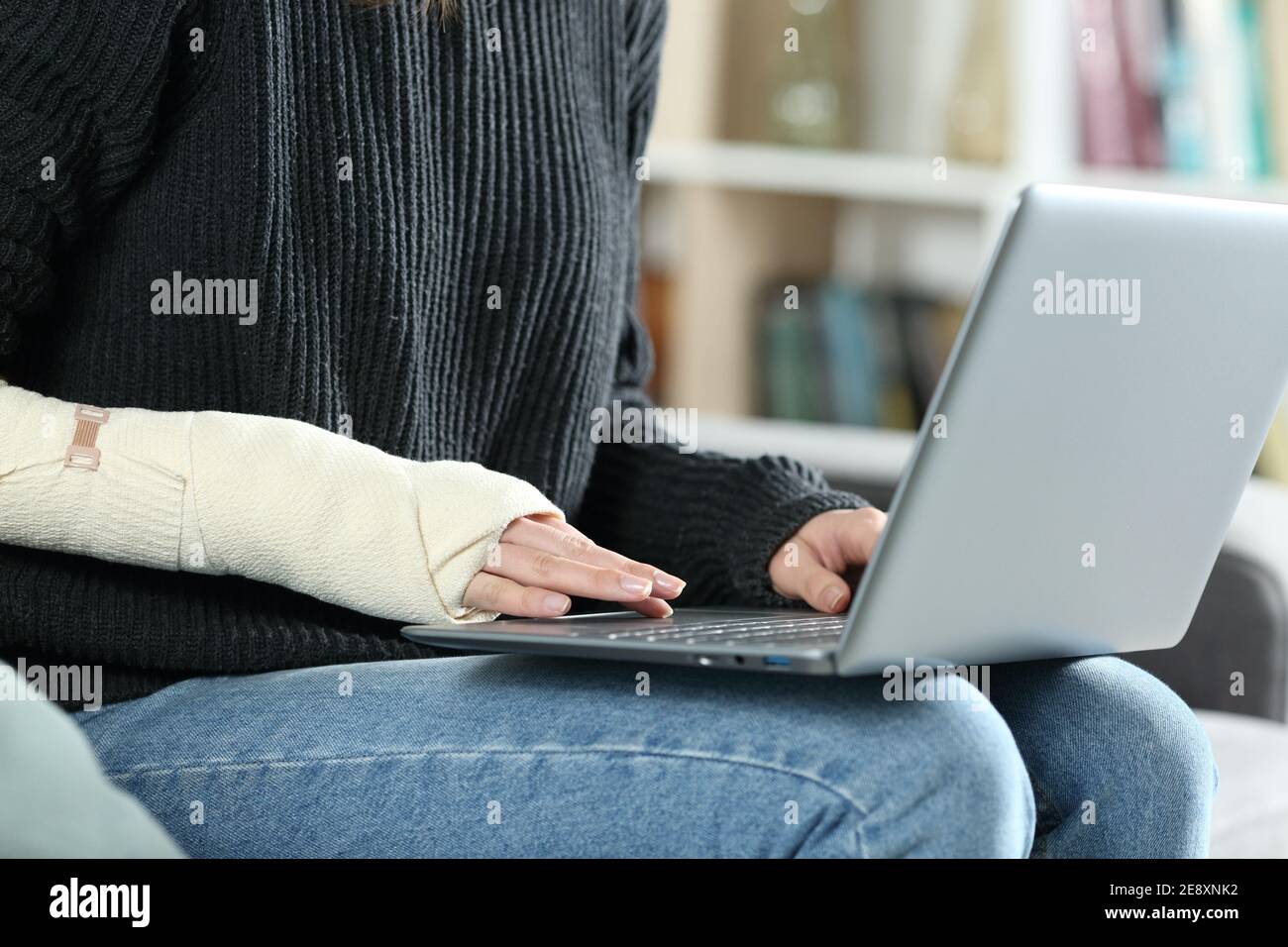 Close up portrait of a disabled woman hands with bandaged arm writing ...