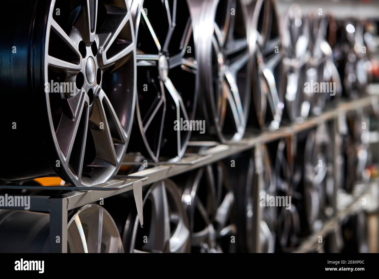 stand with alloy wheels in modern tire store, close up photo of auto ...