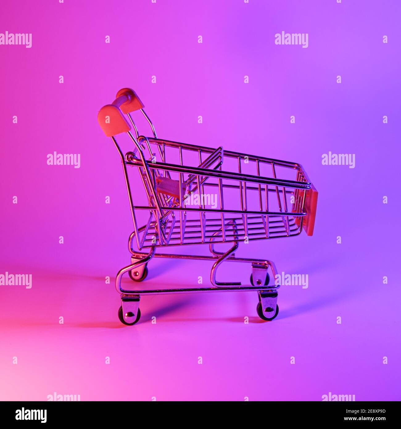 Shoping trolley with in trendy neon light. Gradient pink-blue glow ...
